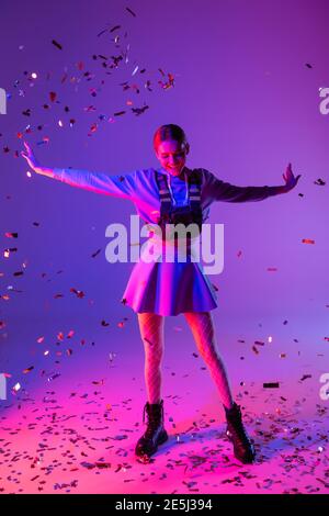 cheerful woman with outstretched hands near confetti on pink Stock ...