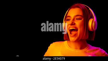 Overjoy. Caucasian woman's portrait on black studio background in pink ...