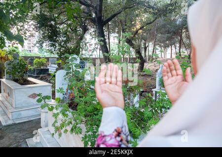 muslim woman rising her hands praying to allah for the dead peoples in ...