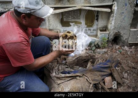 Exposed human skeleton and skull in a burial mound in the Andes still ...
