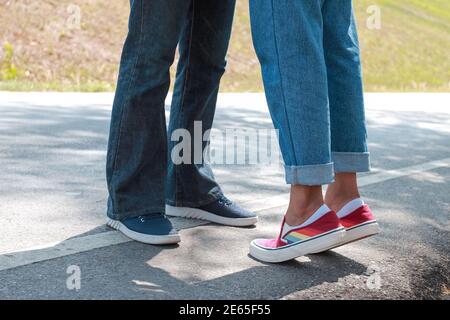 woman stands on tiptoe kissing her partner in the middle of an alleyway ...