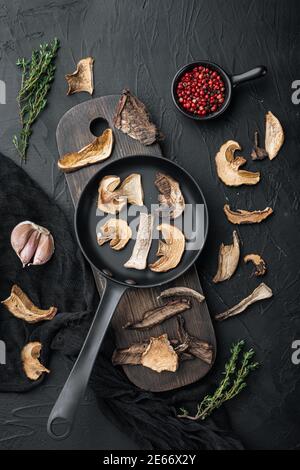 Dried porcini mushrooms, on black background, top view flat lay , with ...