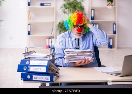 Aged businessman clown working in the office Stock Photo - Alamy
