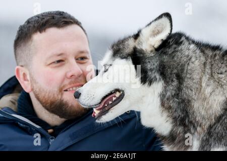 Men playing with siberian husky in winter forest and park, animals and ...