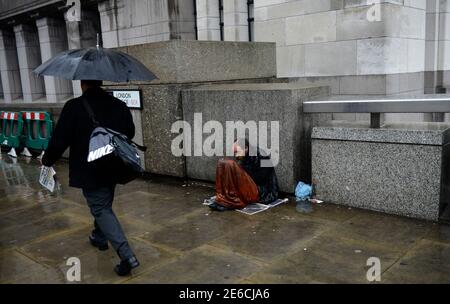 A homeless man sits in the rain with his dog in London Stock Photo - Alamy