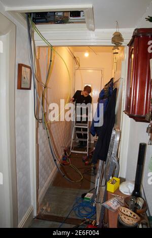 Electrician refitting and testing a new fuse board and safety checking ...