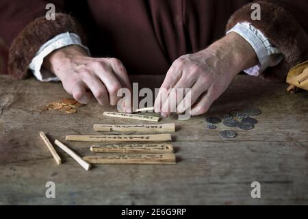 Medieval merchant counting money using tally sticks Stock Photo - Alamy
