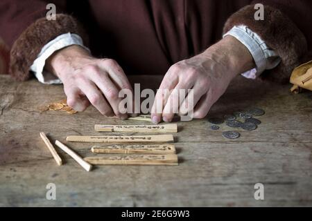 Medieval merchant counting money using tally sticks Stock Photo - Alamy