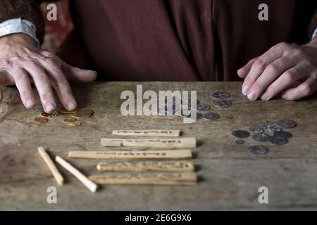 Medieval merchant counting money using tally sticks Stock Photo - Alamy