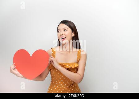 Young woman with paper heart on pink background. Valentine's Day ...