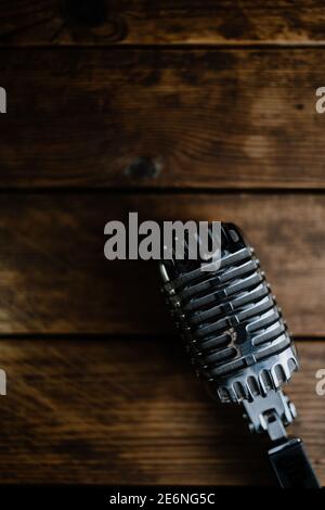Generic retro style microphone on warm wooden background with copy ...