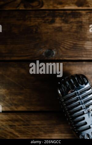 Generic retro style microphone on warm wooden background with copy ...