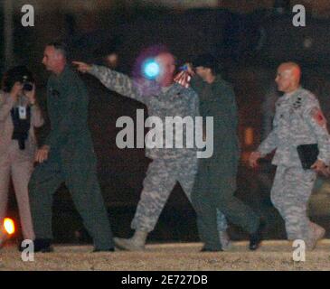 Foreign aid workers and military personnel work together to unload a ...