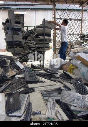 Workers in computer recycling plant holding hard drive Stock Photo - Alamy