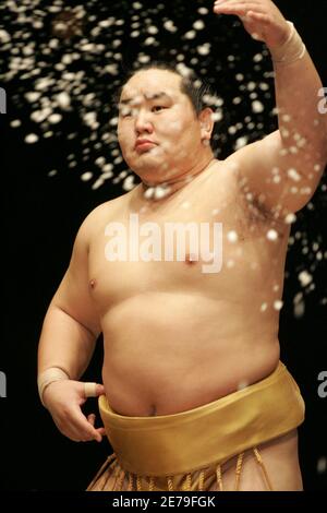 A Sumo wrestler throws salt during the pre fight preparation ritual at ...