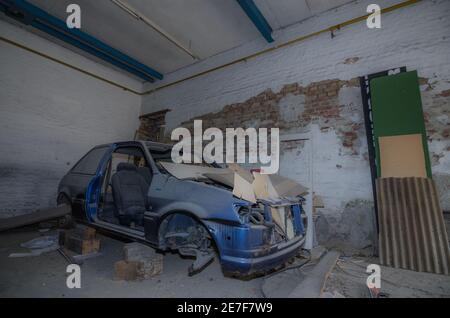 Disassembled blue car in a workshop, showing detailed paint work on the ...