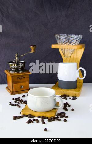 A vertical shot of a wooden coffee drip set with mugs on a table ...