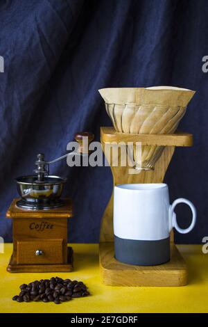 A vertical shot of a wooden coffee drip set with mugs on a table ...