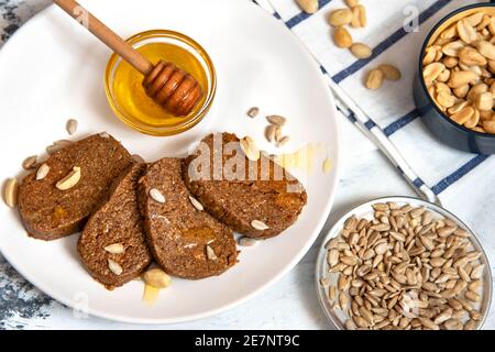 Homemade halva with peanuts and sunflowers watered with honey on a white plate Stock Photo - Alamy