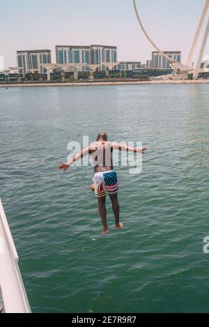 African-American man jumps off from a ship to save someone on the sea ...