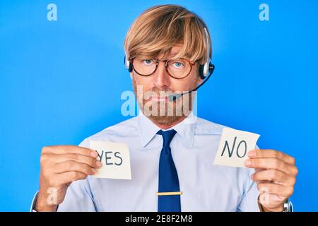 Young blond man wearing operator headset working at online shop ...