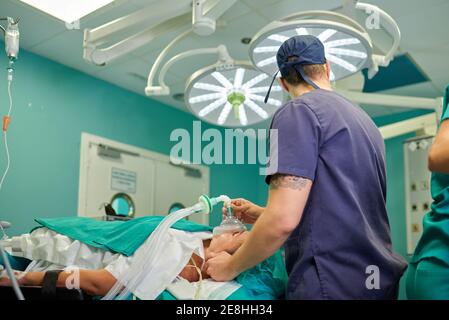 Side view of anonymous male anesthesiologist in medical uniform and cap ...