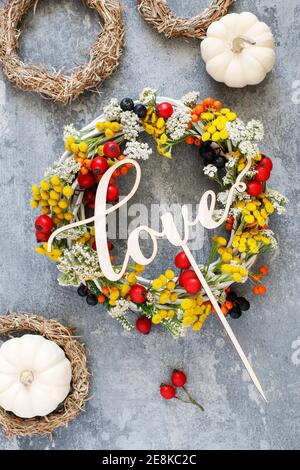 Autumn wreath with rose hip, tansy and spiraea on white wooden ...