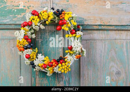Autumn wreath with rose hip, tansy and spiraea on white wooden ...