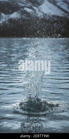 water splatter after throwing a rock into a mountain lake Stock Photo ...