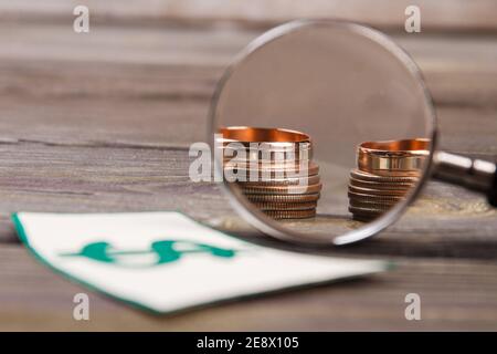 Magnifying glass on money stacks that gradually increase, check the ...