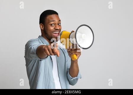 Positive african guy shouting with megaphone over blue background Stock ...
