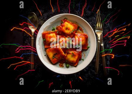 Italian ravioli with tomato sauce exciting celebration with neon light ...