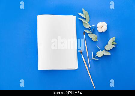 Blank magazine and brushes on color background Stock Photo - Alamy
