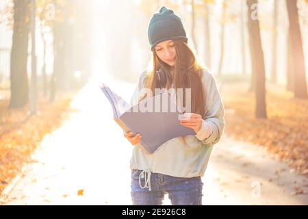 Cute teenage girl reading notes in park Stock Photo - Alamy