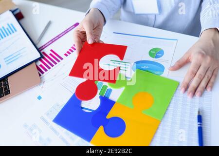 Business woman folding colorful puzzle over documents closeup Stock ...