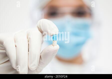 Female UK pharmacist wearing PPE personal protective equipment holding ...