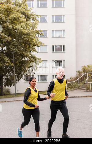 Visually impaired woman jogging with guide runner Stock Photo - Alamy