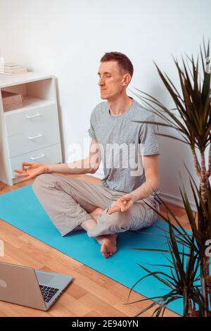 The young man doing yoga in bedroom Stock Photo - Alamy