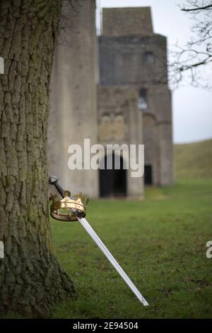 Crown and sword rest against tree outside castle keep Stock Photo - Alamy