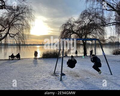 31 January 2021, Hamburg: Sunset over the ice on the water of the ...