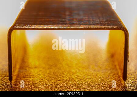 Coppered staples photographed close-up in brown tones. Three groups of ...