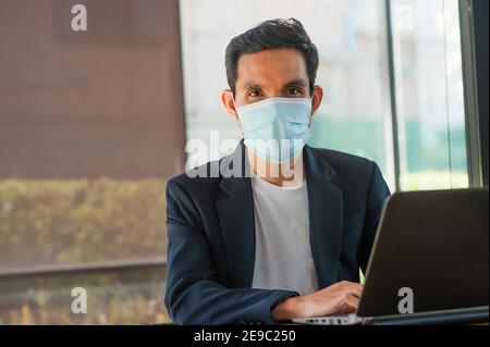 Asian businessman wear facemask working laptop computer in office Stock ...