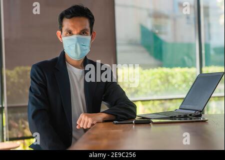 Asian businessman wear facemask working laptop computer in office Stock ...