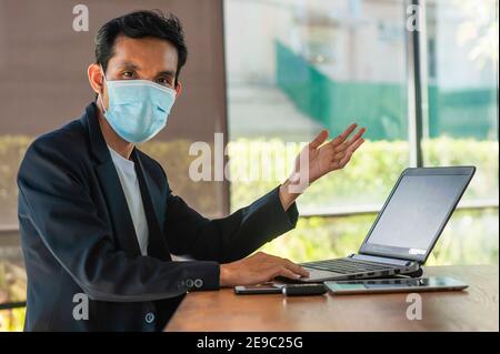 Asian businessman wear facemask working laptop computer in office Stock ...