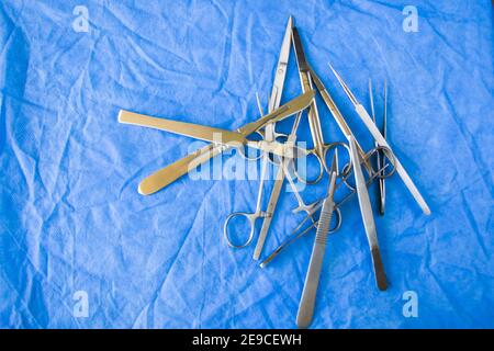 A top view of a sterile dissection kit on a blue surface in the ...