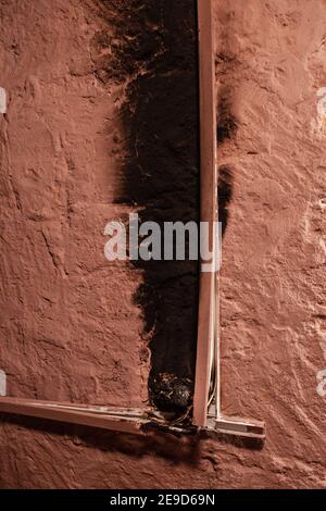Short circuit, burnt wires. traces of smoke and fire on the wall. The ...