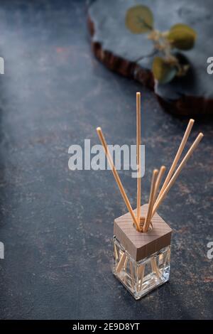 Dark glass diffuser bottle with natural reed sticks and a brown wood ...