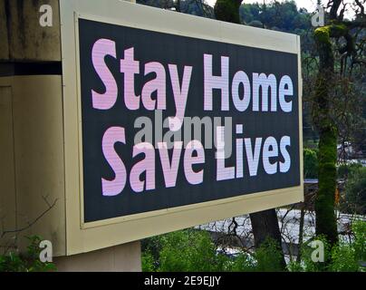 STAY HOME and COVID-19 sign on message board with a blue medical mask ...