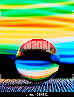Vertical shot of a reflective ball with an illuminated colorful ...