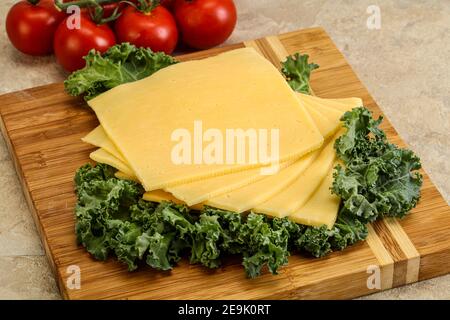 Sliced Gauda cheese snack over board Stock Photo - Alamy
